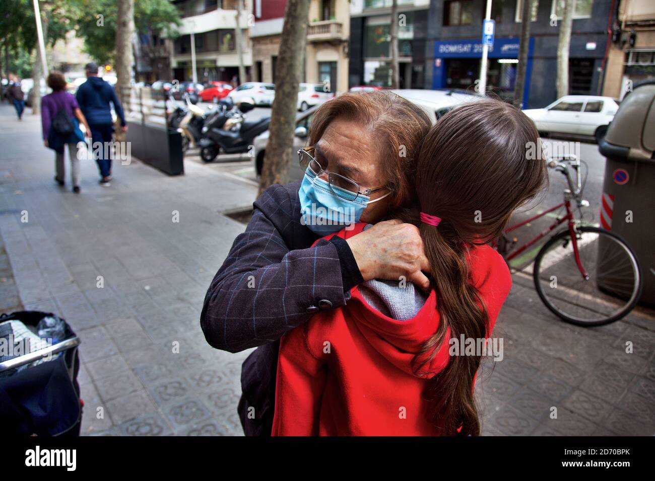 Boy giving his grandmother a cautious hug goodbye, Barcelona, Spain ...