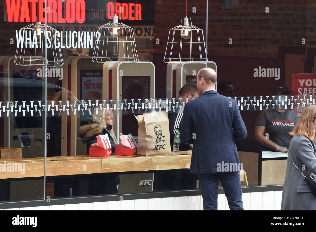 The Duke of Cambridge makes a woman laugh as he looks in on customers ...