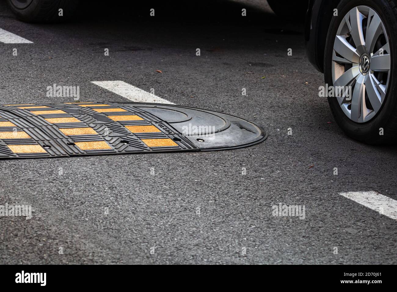 Traffic safety speed bump on an asphalt road in a parking area in ...