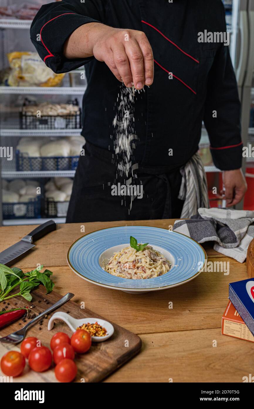 The chef puts pasta from the pan and do the plating Stock Photo - Alamy
