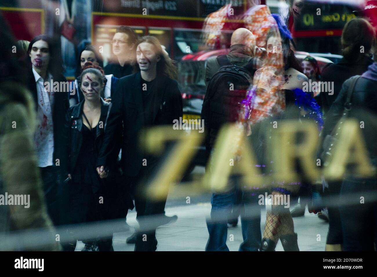 People dressed as zombies reflected in shop windows along Oxford Street ...