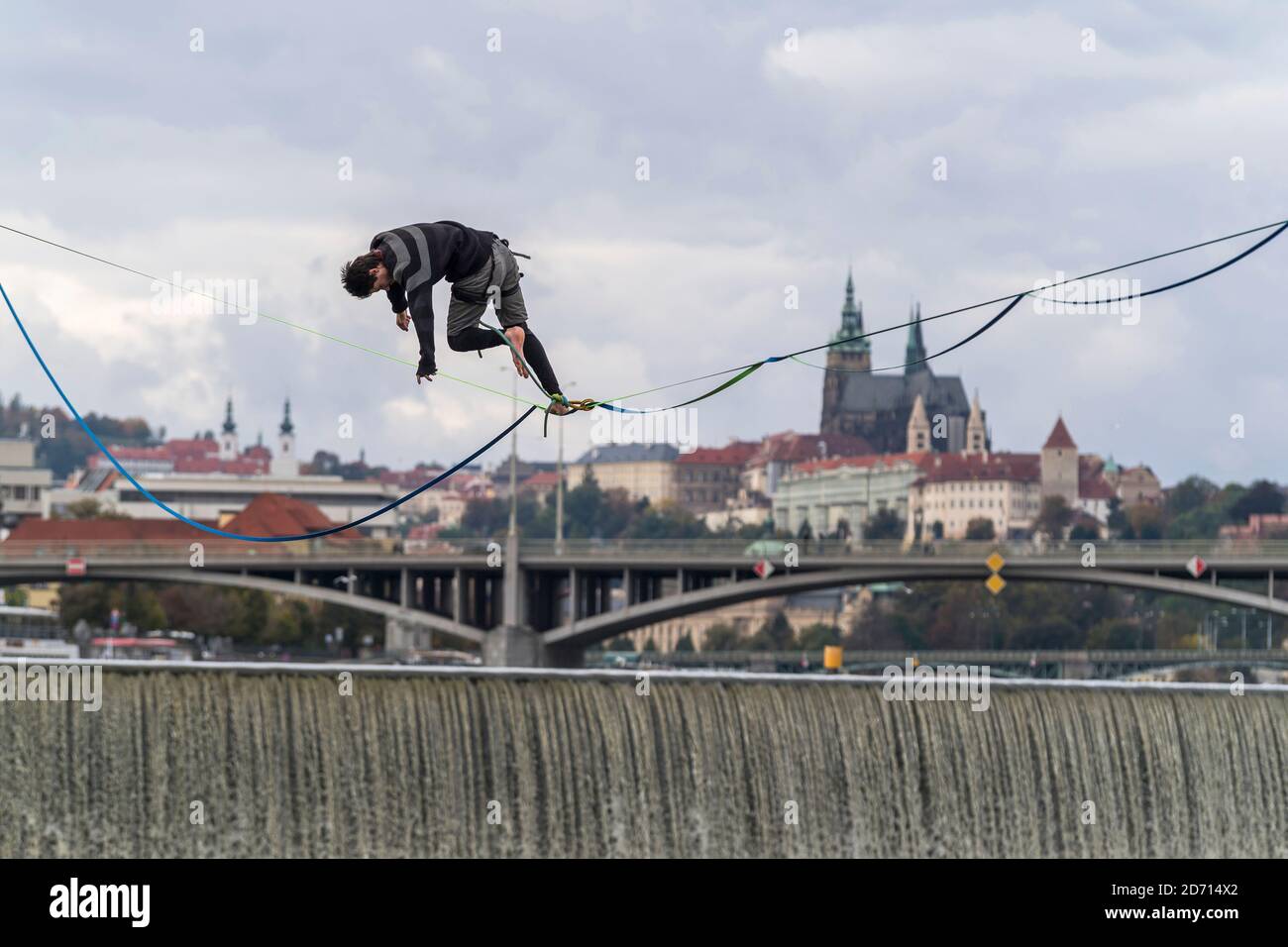 a tightrope walker falling off from slack line above the Vltava river ...