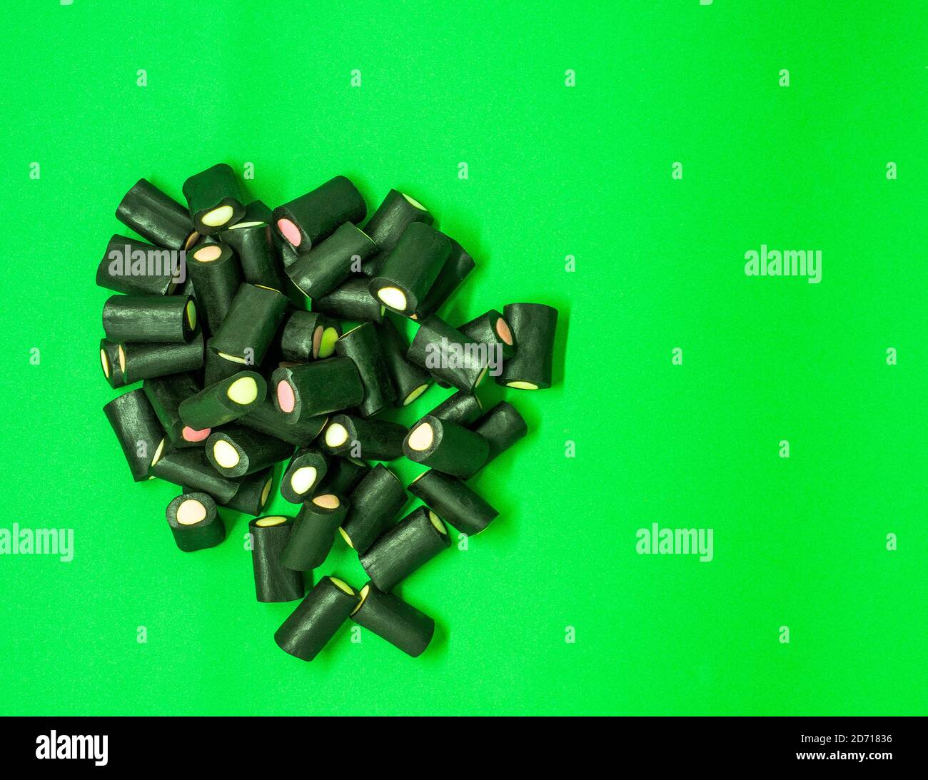 Top view shot of L licorice candies on a green table Stock Photo - Alamy