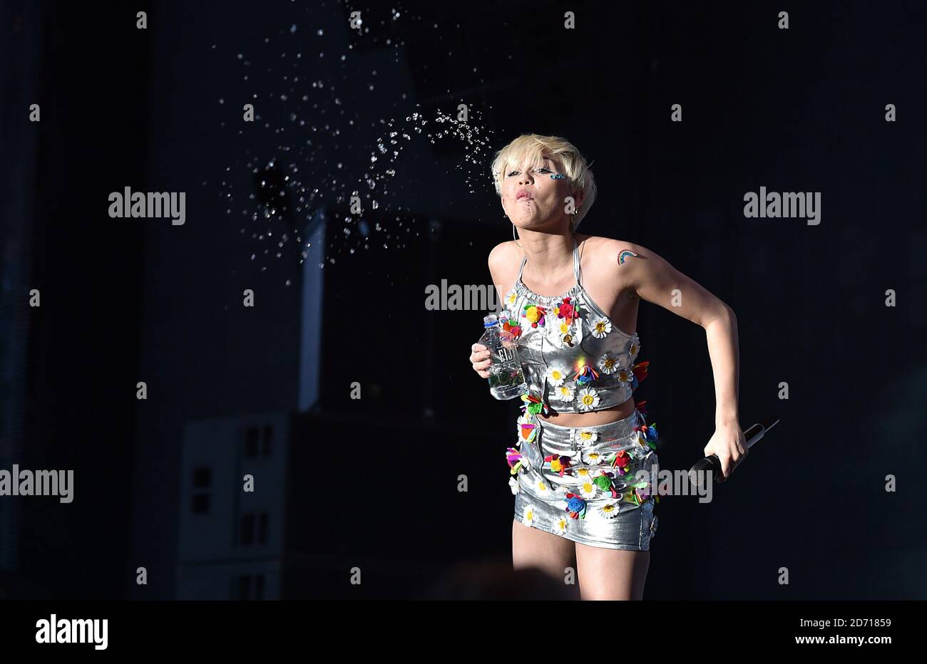 Miley Cyrus spits water into the crowd as she performs during Capital ...