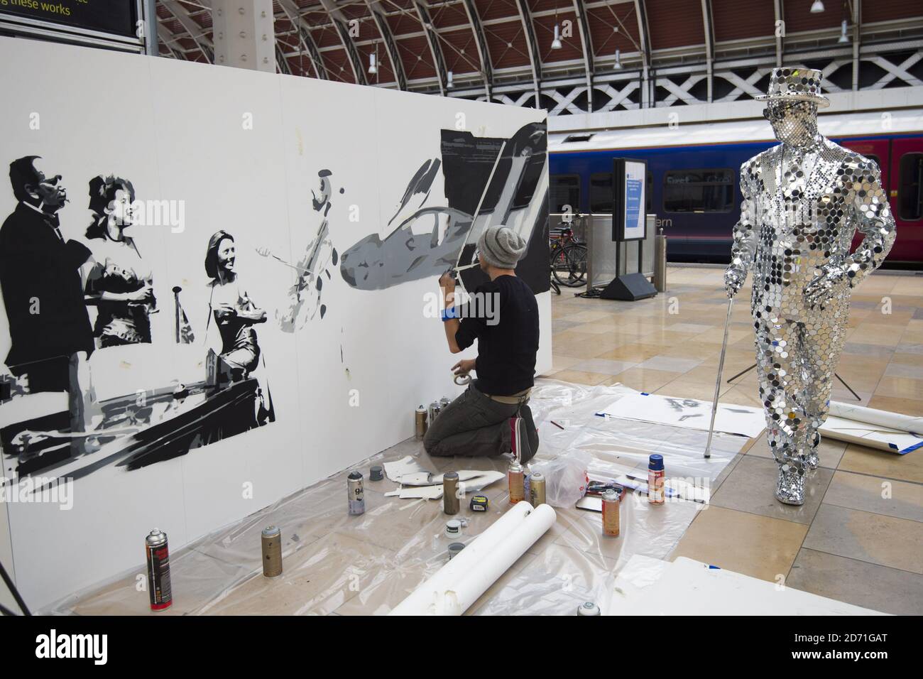 Graffiti artist Tom Cat, watched by the Mirror Man, creates an artwork ...
