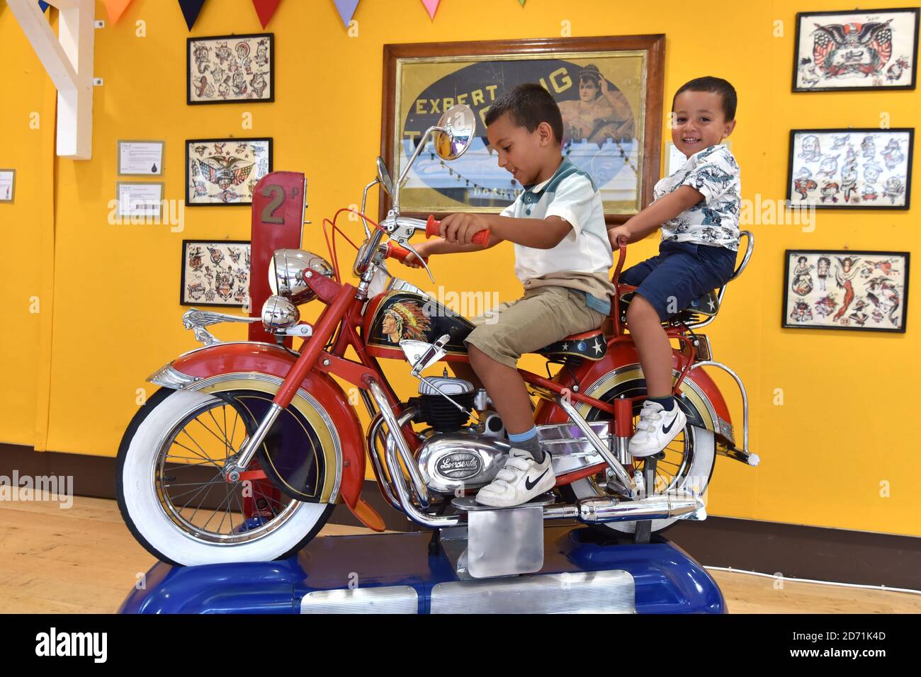 Noah, aged 3, and Joshua, aged 5, try out a 1960s motorbike arcade ride ...