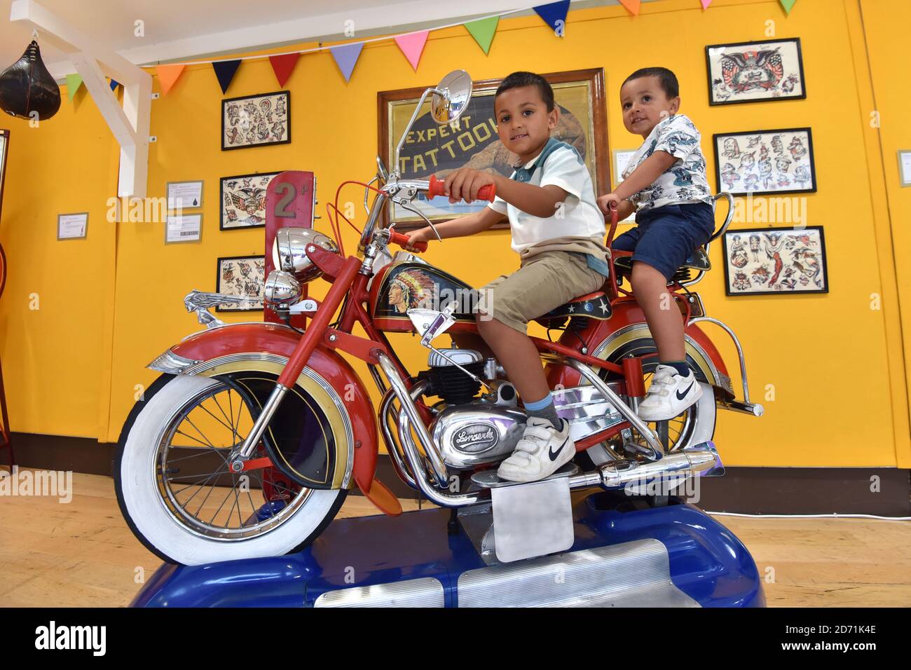 Noah, aged 3, and Joshua, aged 5, try out a 1960s motorbike arcade ride ...