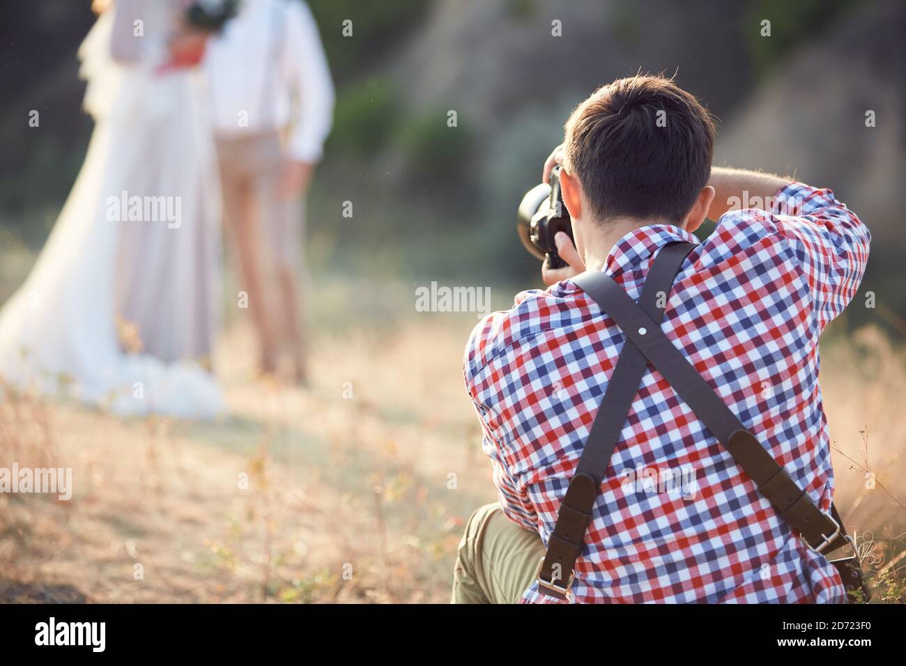wedding professional photographer takes pictures of the bride and groom ...
