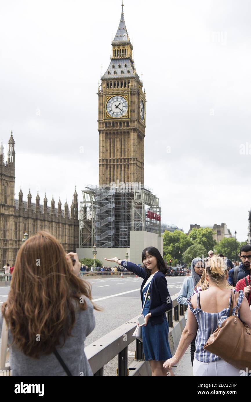 Tourists take photos on Westminster Bridge in London. Picture date ...