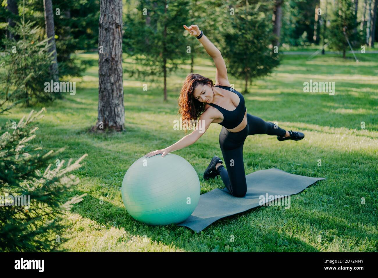 Flexible active woman in sportsclothes makes fitness exercises on ...