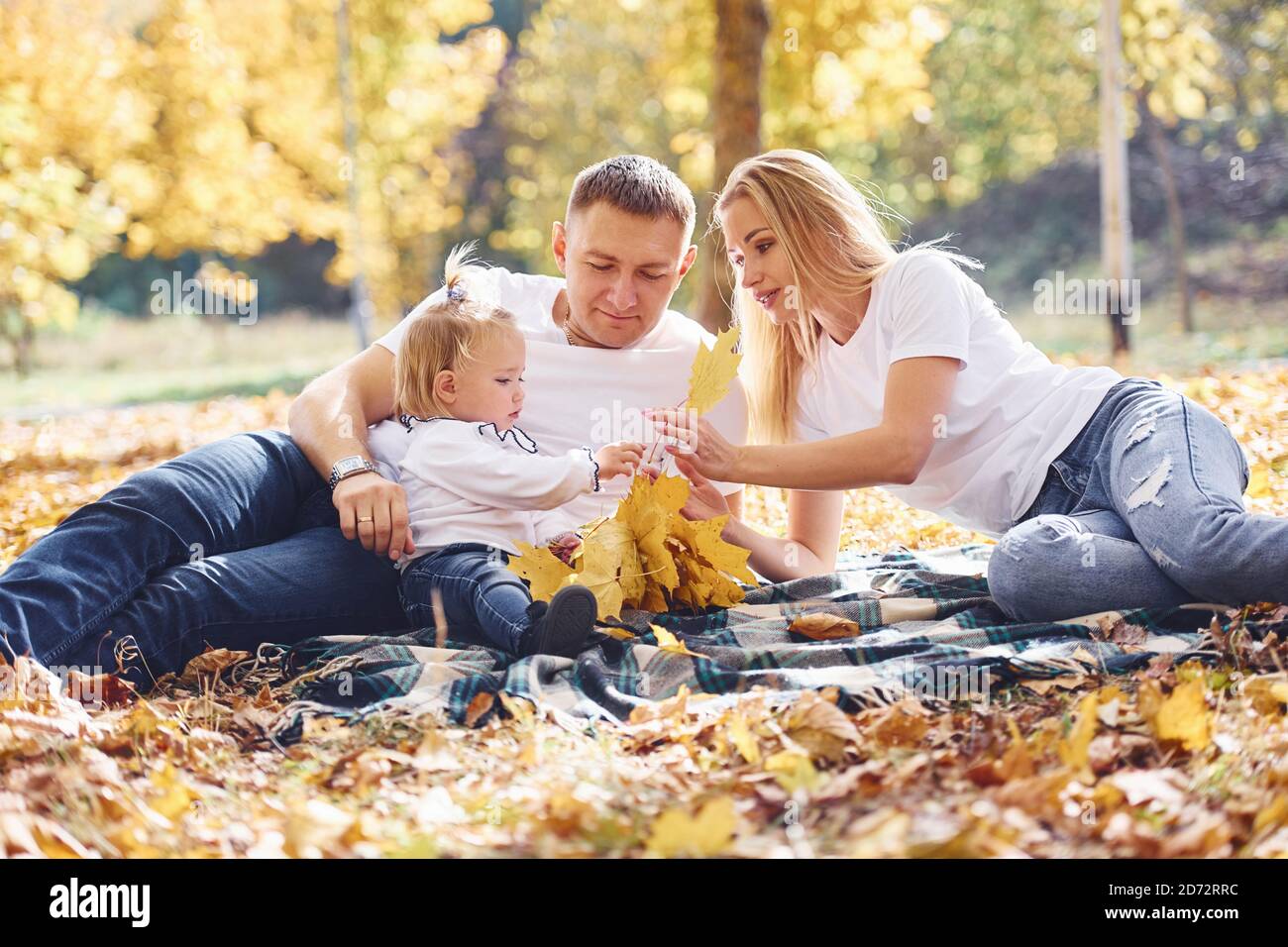 Cheerful young family lying down on the ground and have a rest in an ...