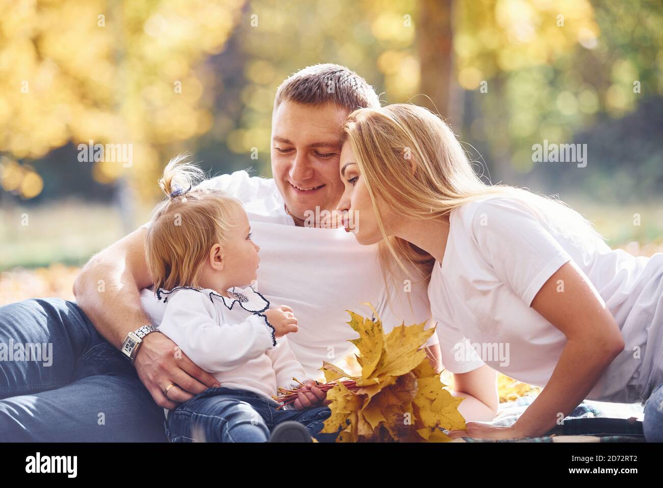 Cheerful young family lying down on the ground and have a rest in an ...
