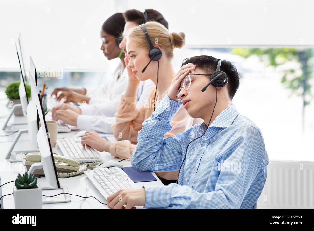 Overworked male hotline agent sleeping in front of computer monitor at ...