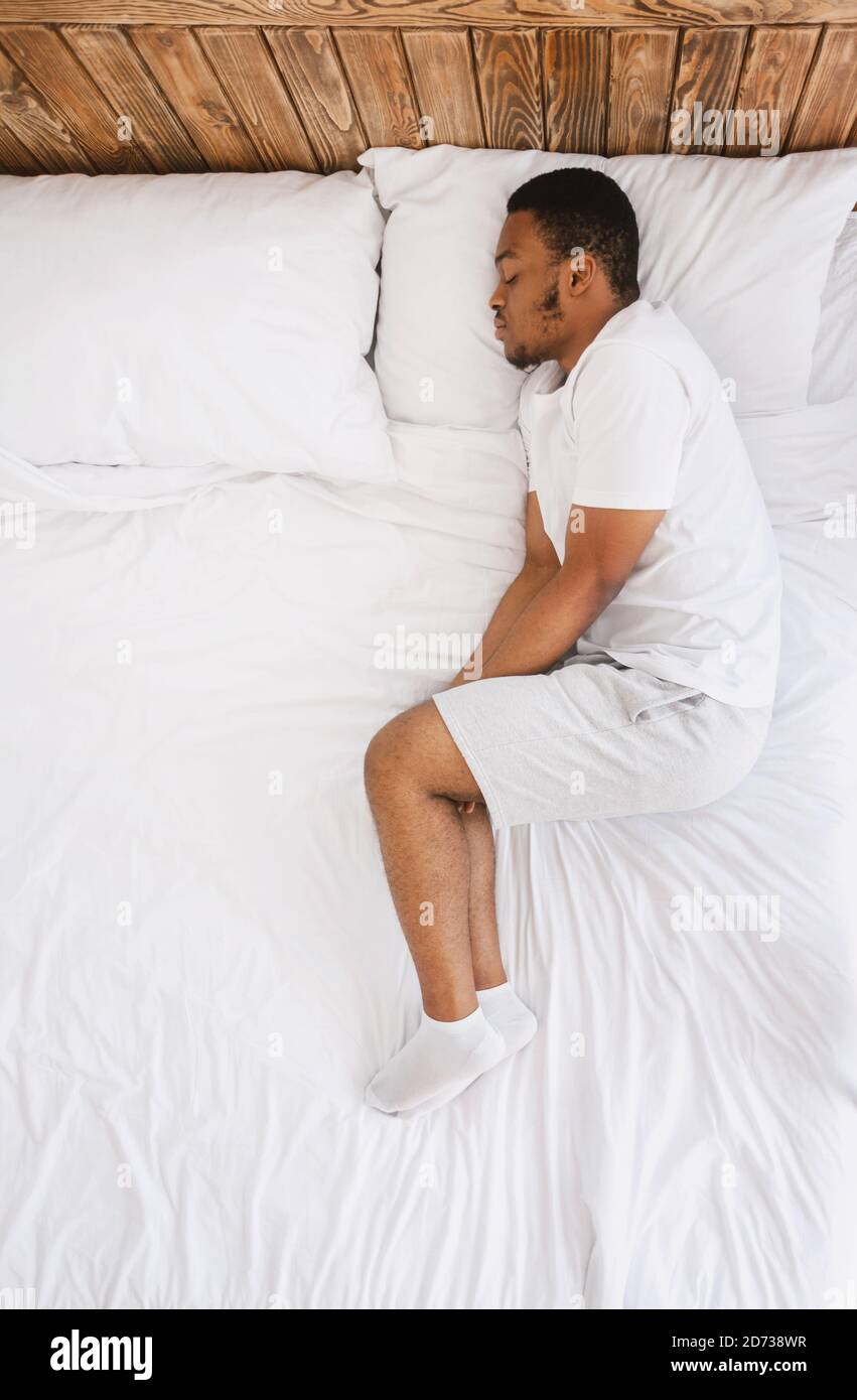 African American Guy Sleeping Lying In Bed At Home Top View Stock