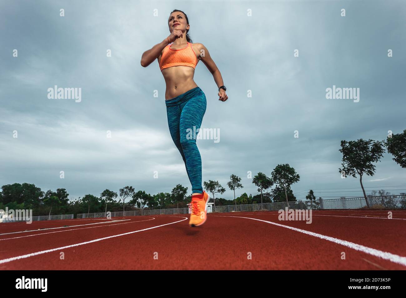 Female sprinter athlete starts a race on a racetrack Stock Photo - Alamy