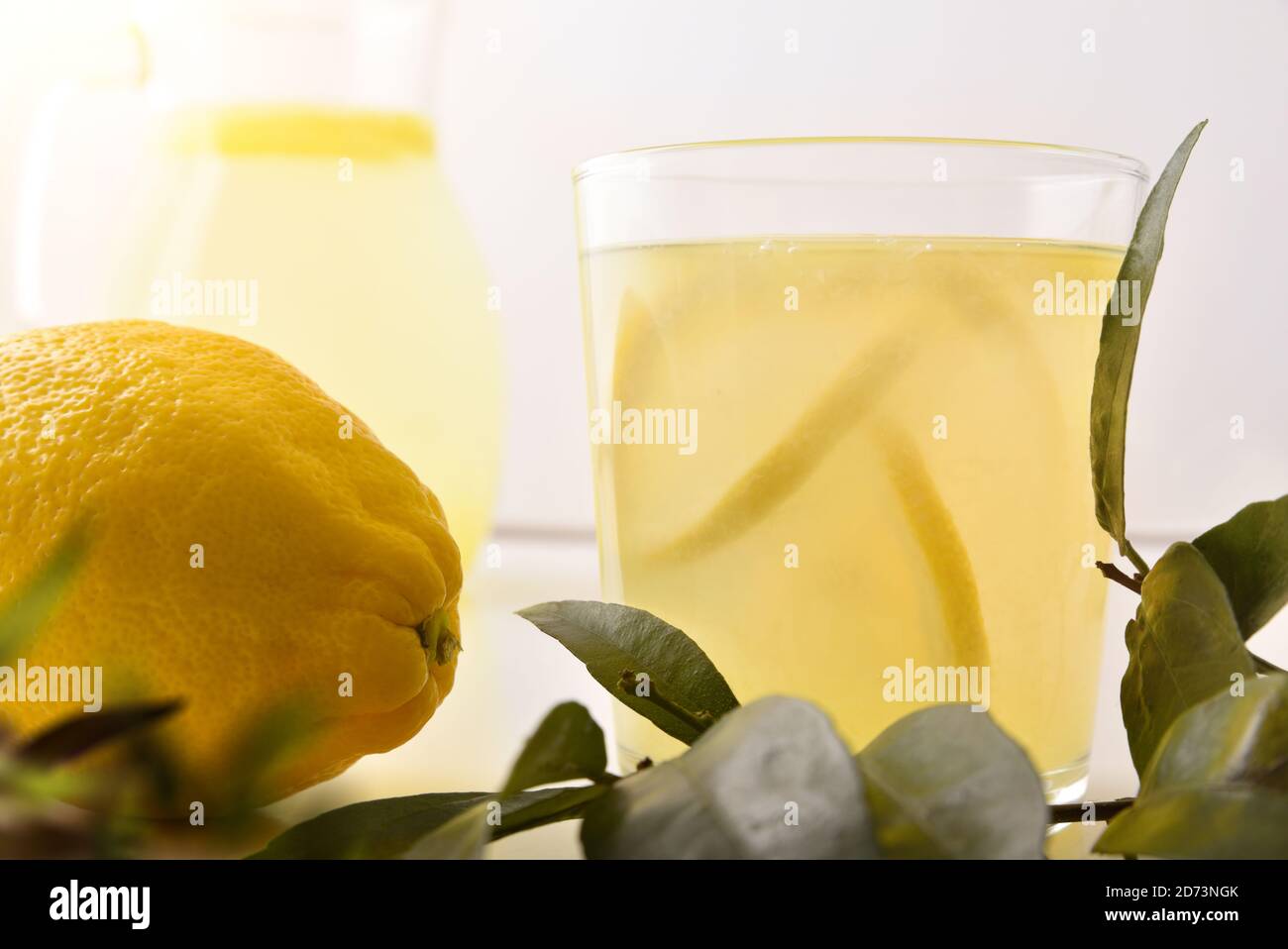 Glass filled with freshly squeezed lemon juice with lemon piece ...