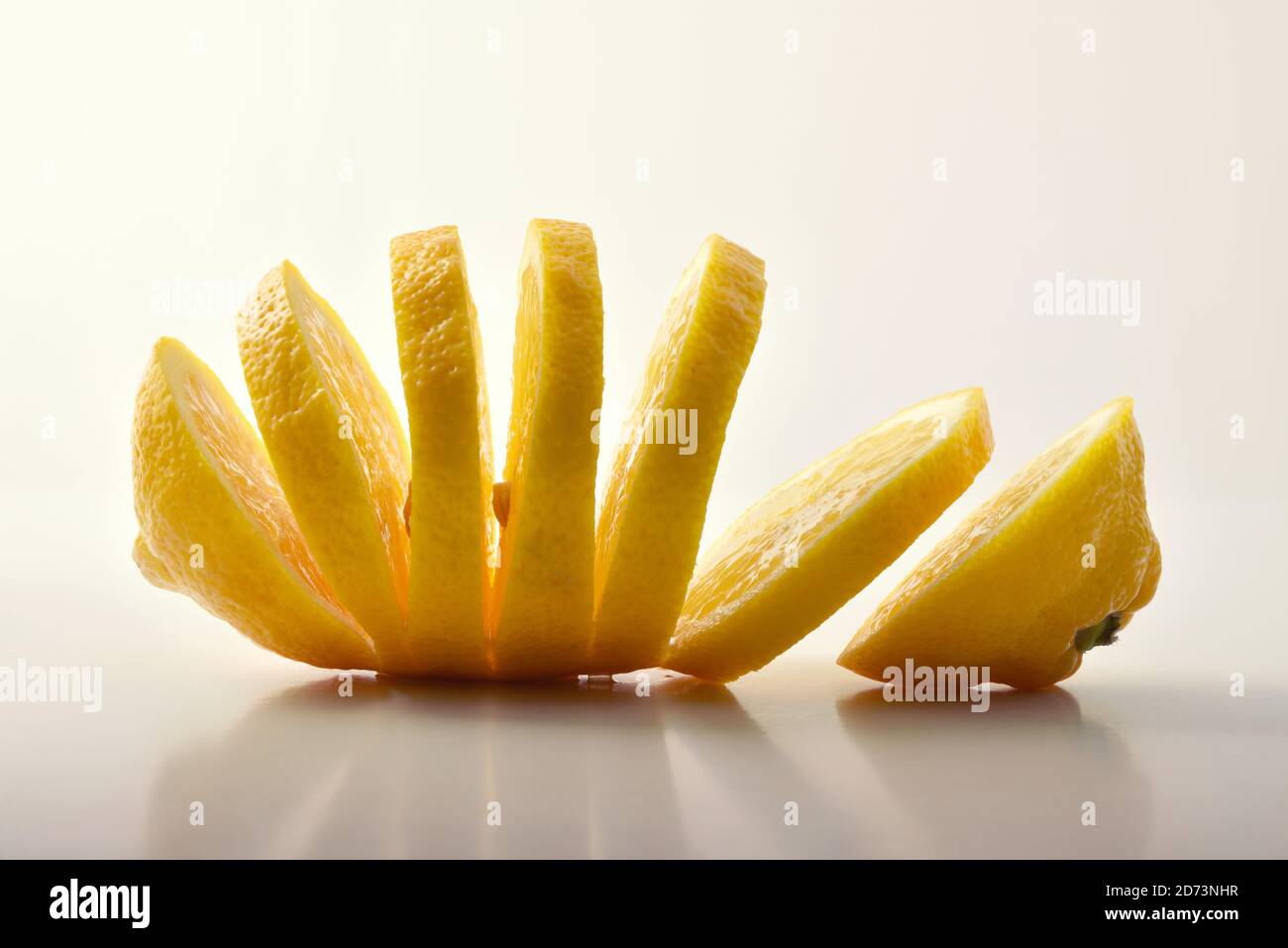 Detail of lemon sectioned on a white table and white isolated ...