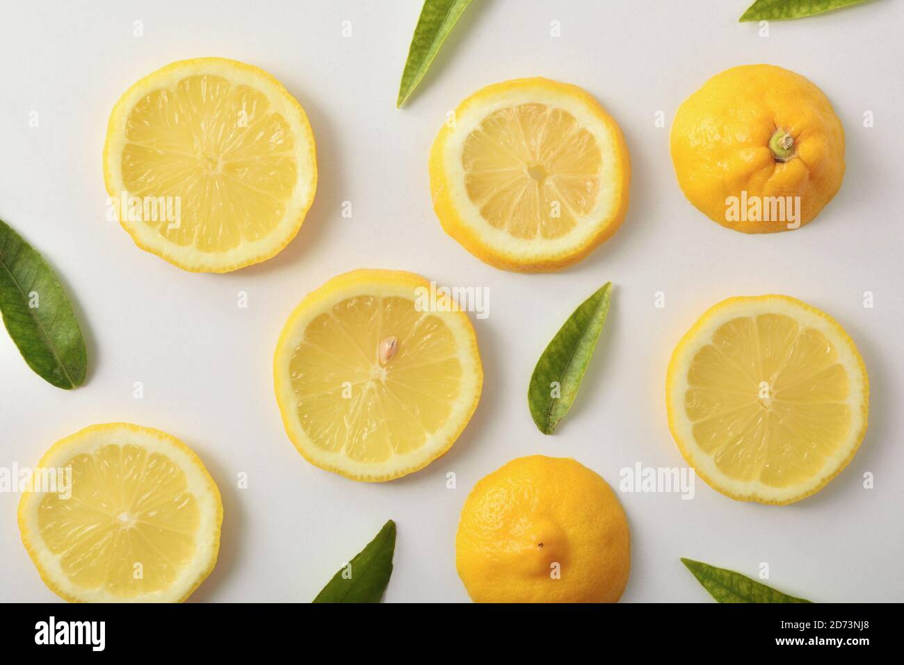Detail of several cuts of lemon on white table. Top view. Horizontal ...
