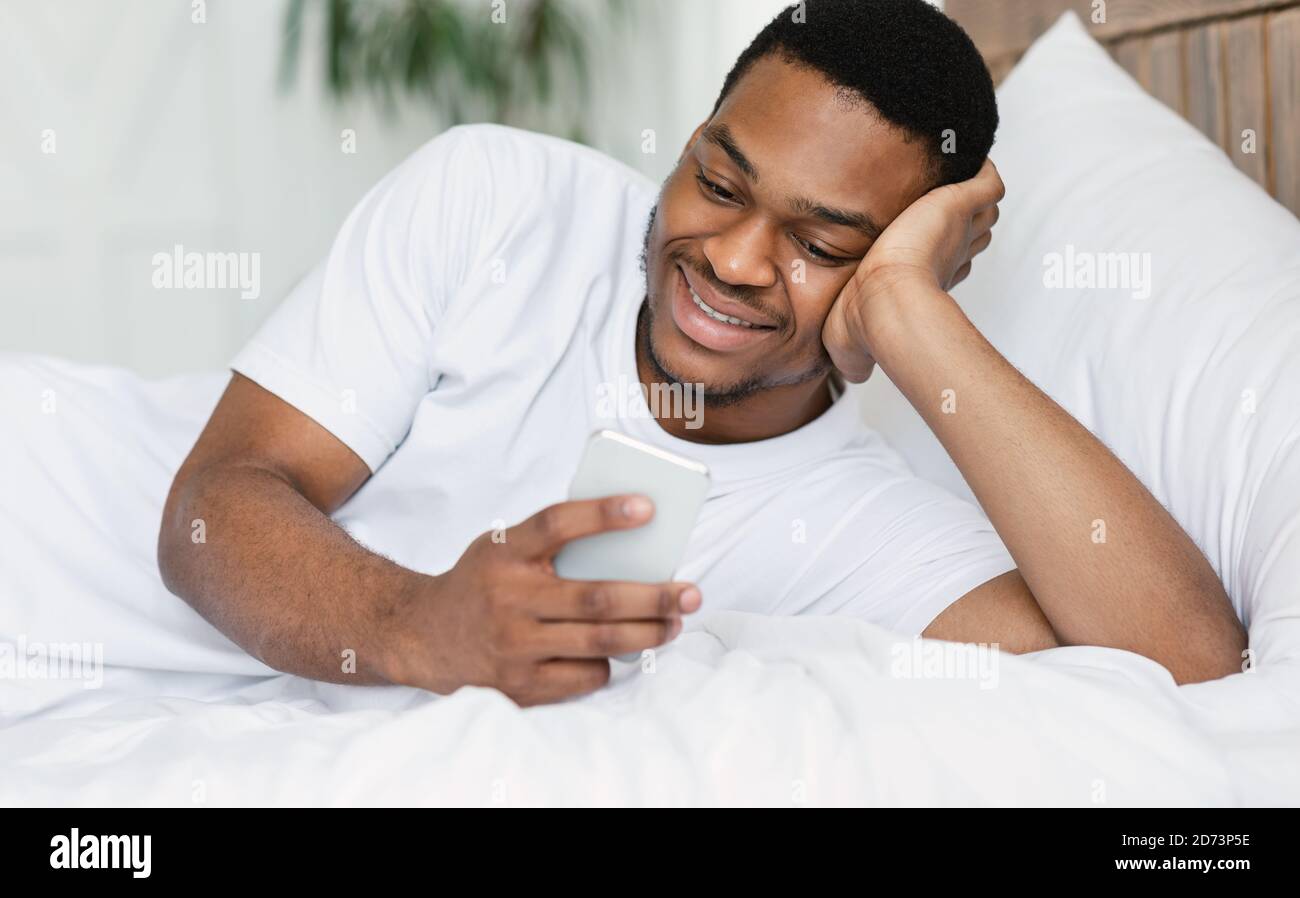 Man texting bed hi-res stock photography and images - Alamy