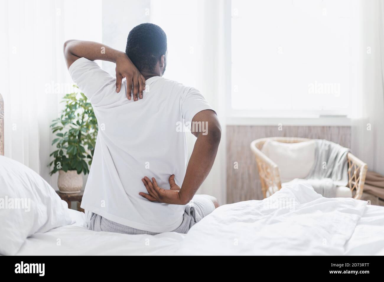 African Man Touching Aching Back And Neck At Home Stock Photo - Alamy