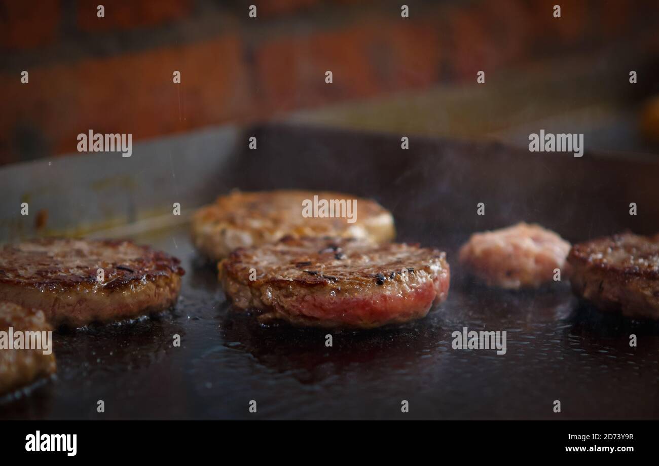 Beef meat patty frying on hot pan in fast food restaurant kitchen for ...