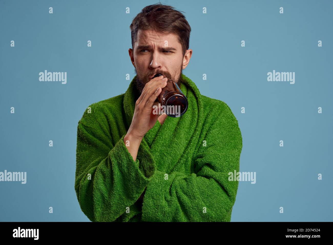 drunk man in a green robe with a bottle of beer in his hand on a blue ...