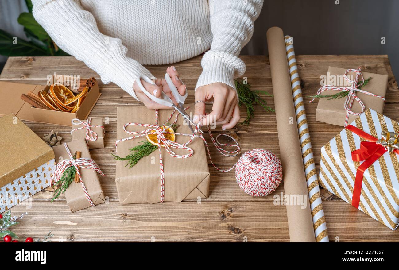 Woman s hands wrapping Christmas gift, close up. Unprepared presents on ...