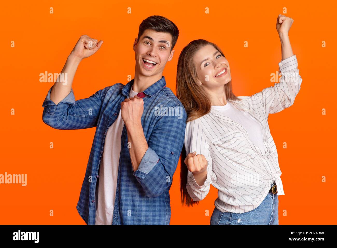 Happy guy and lady in casual clothes celebrate winning and express ...