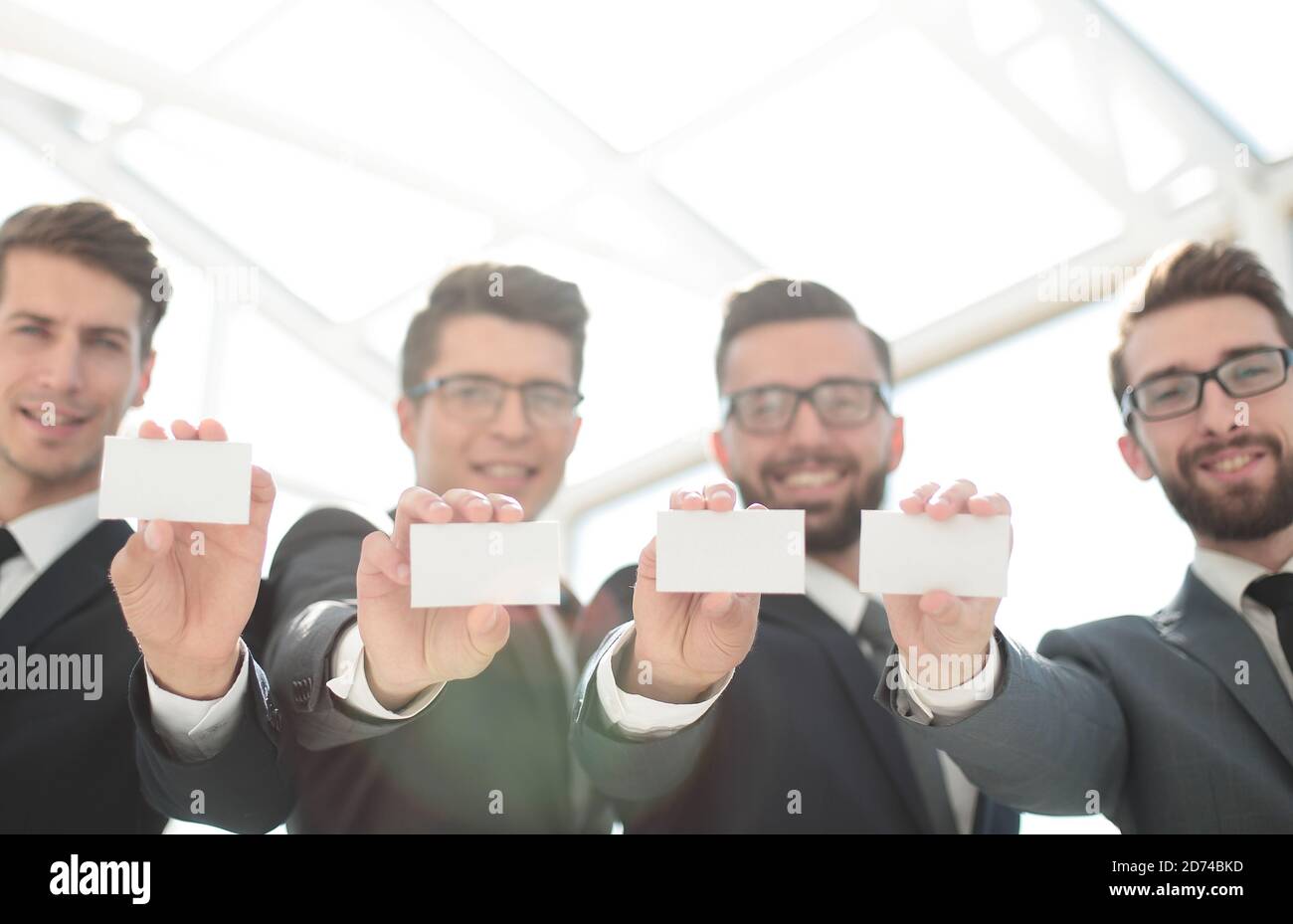 four young business people showing their business card Stock Photo - Alamy