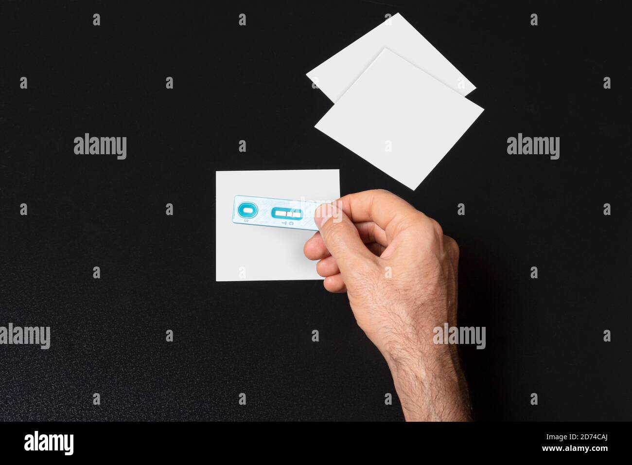 A hand holding a pregnancy test in front of image frames, editable mock ...