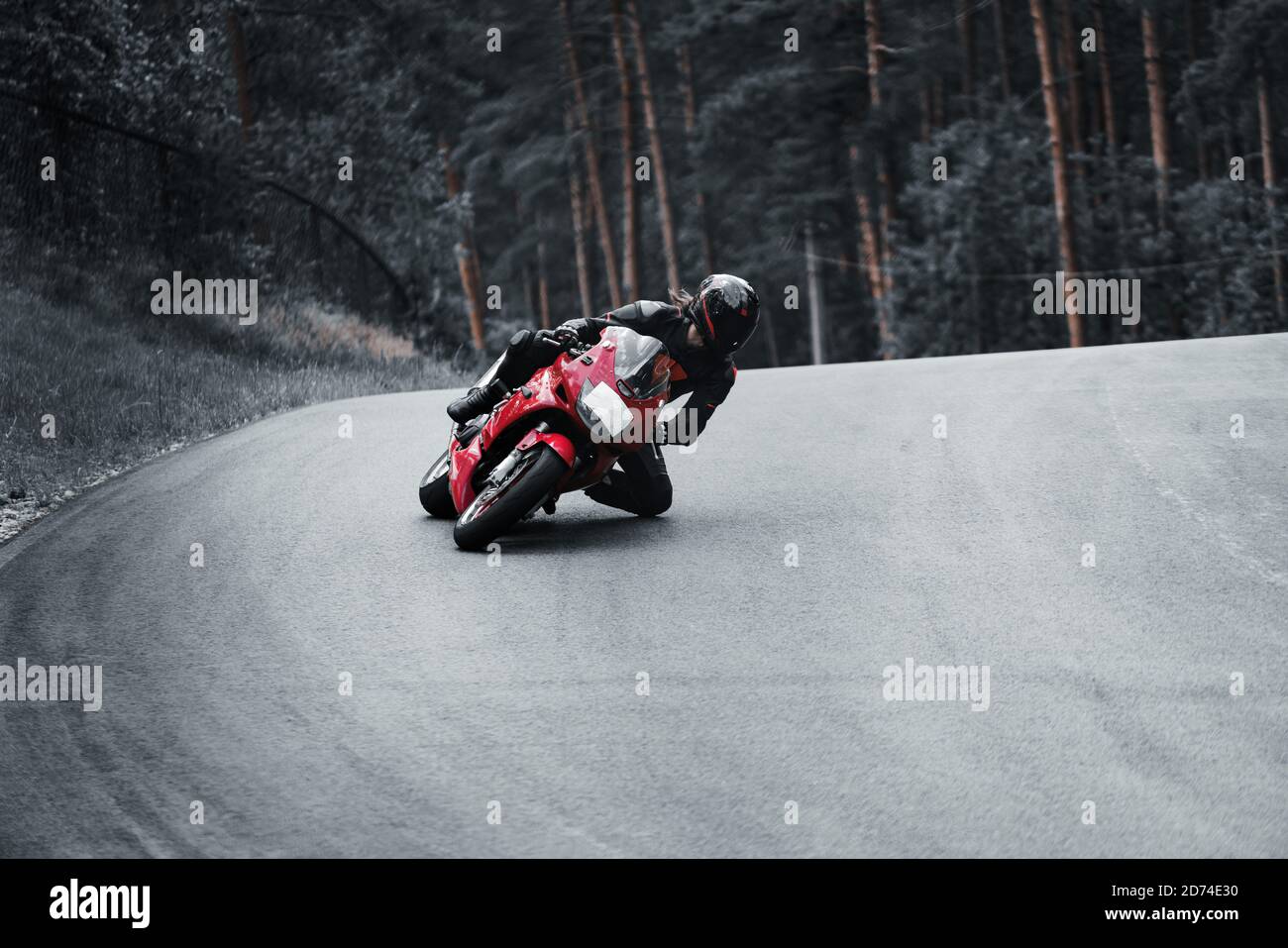 man riding motorcycle in asphalt road. Motorcyclist in black suit at ...