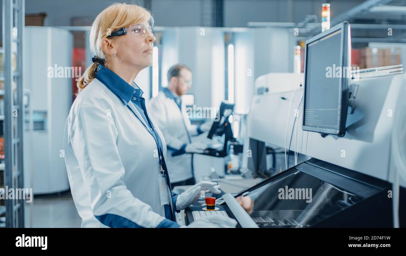 On High Tech Factory Female Engineer Uses Computer for Programing Pick ...