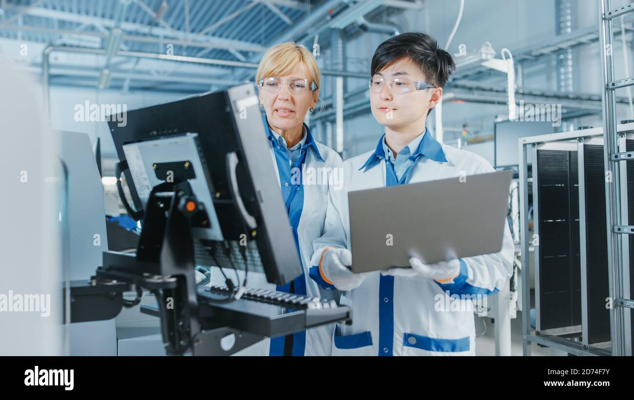On High Tech Factory Asian Engineer Talks with Female Supervisor, Use ...