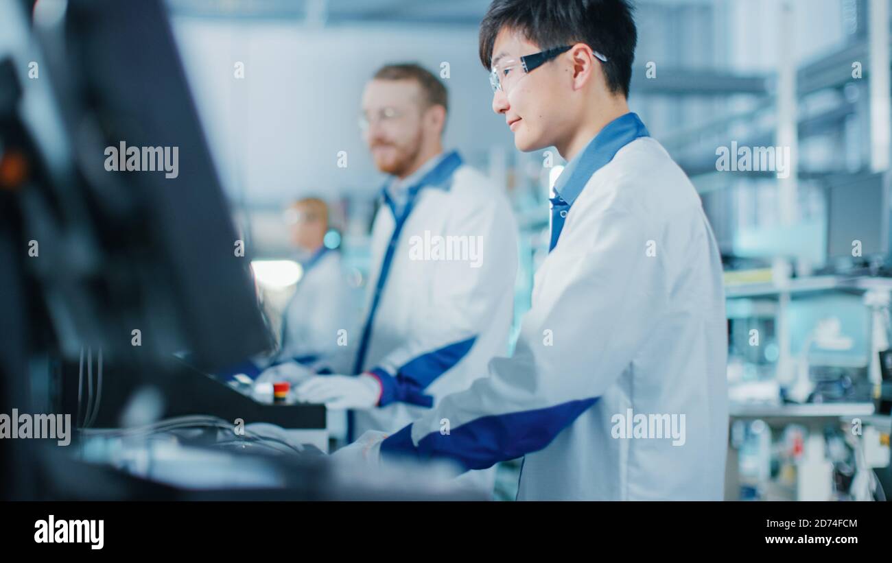 On High Tech Factory Asian Worker Loads Reel into Pick and Place ...