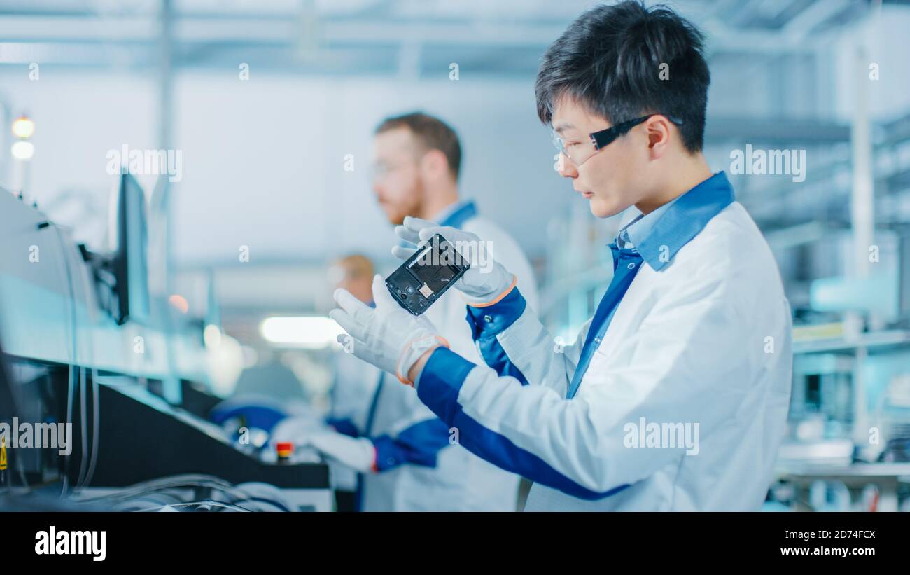 High-Tech Factory: Quality Control Engineer Picks up and Visually ...