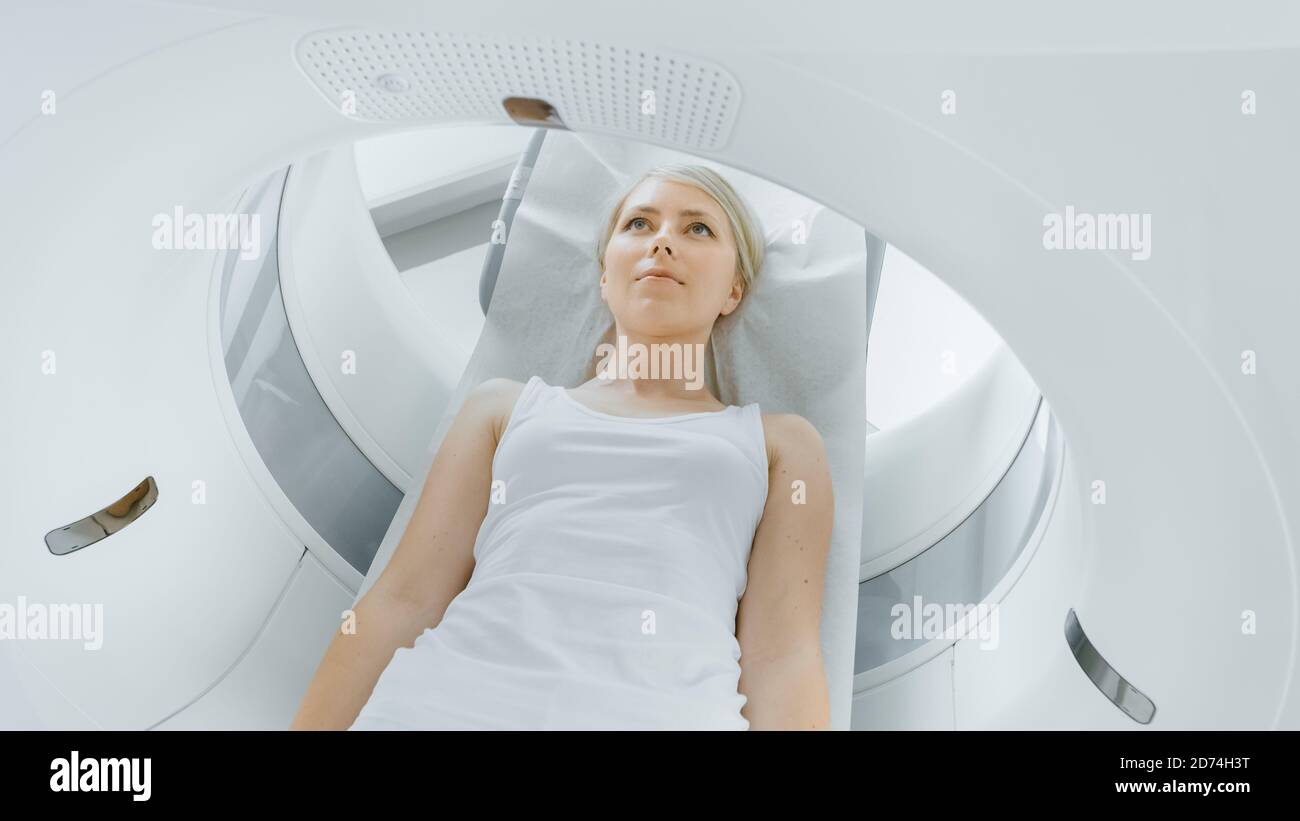 Female Patient Lying on a CT or MRI Scan, Bed is Moving inside Machine Scanning Her Body and ...