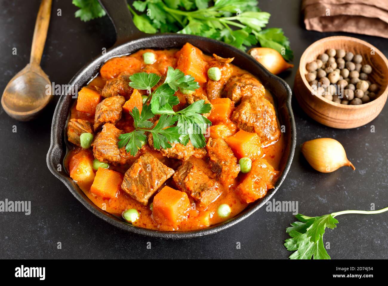 Beef stew with potatoes and carrots in tomato sauce in frying pan ...