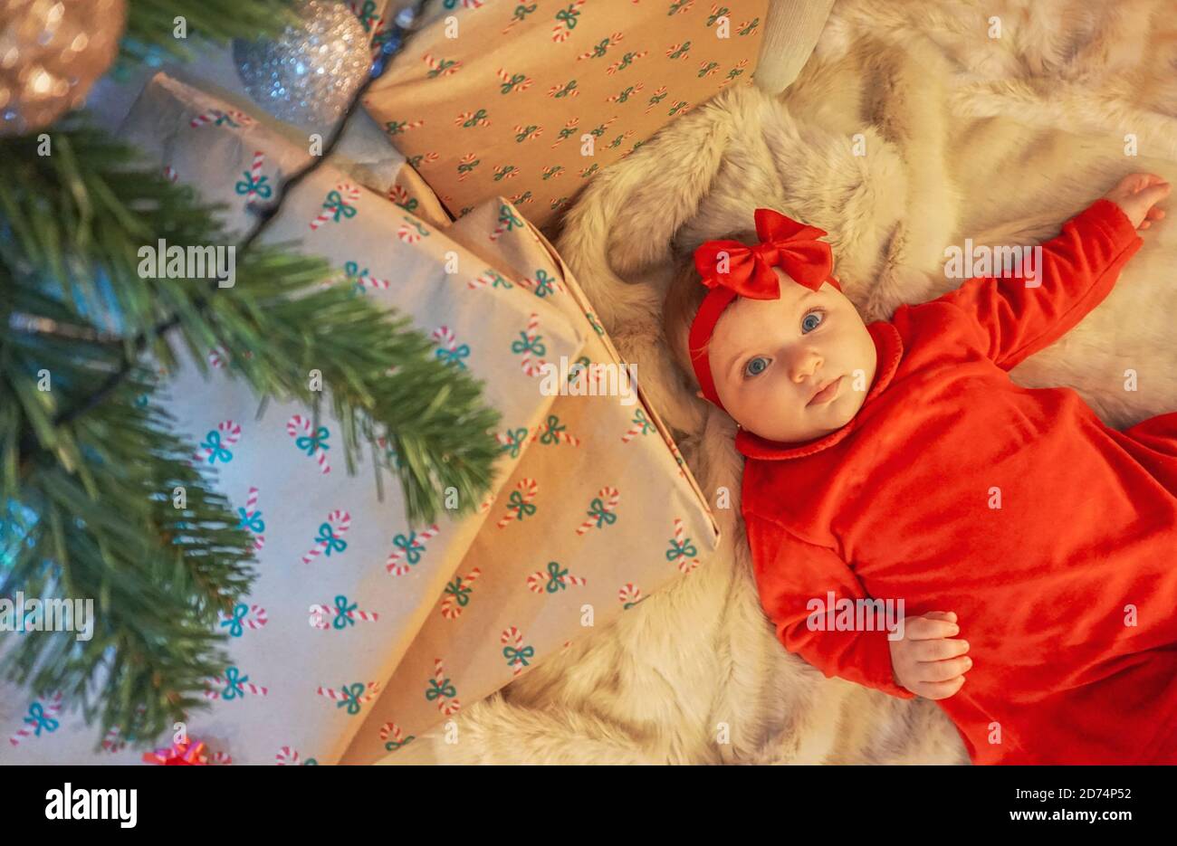 First christmas for baby girl standing under the tree - Newborn in red ...