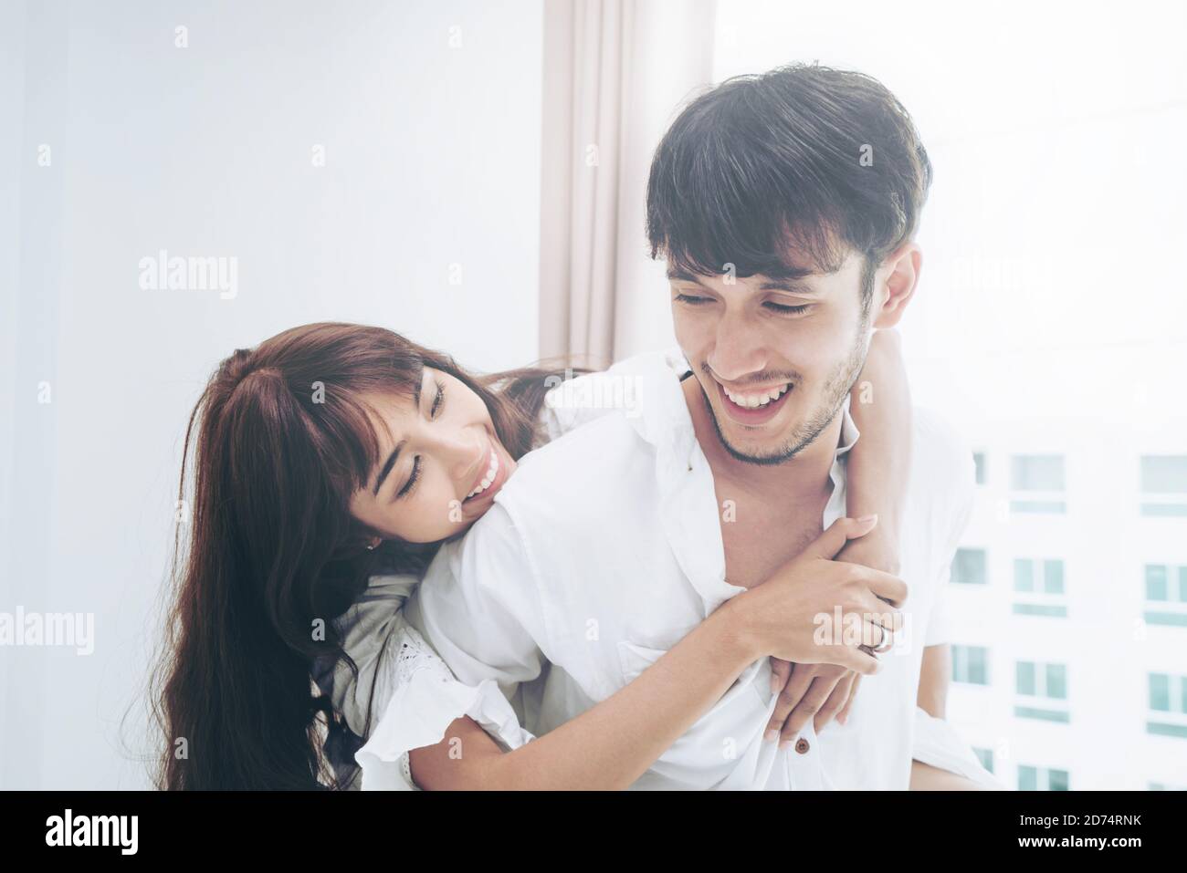 Happy young couple relaxing in home bedroom after waking up in the ...