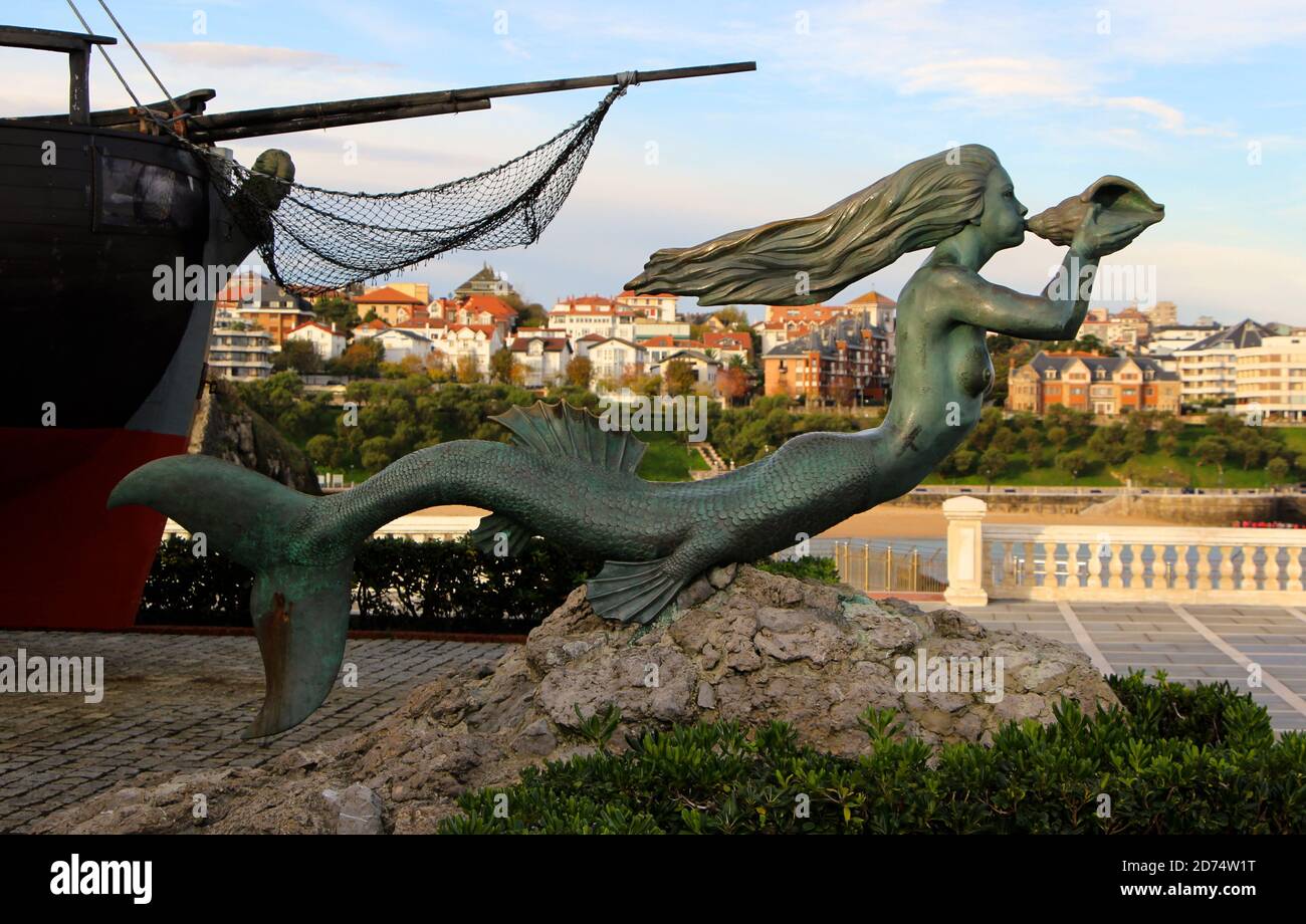Bronze mermaid sculpture with long flowing hair blowing into a conch ...
