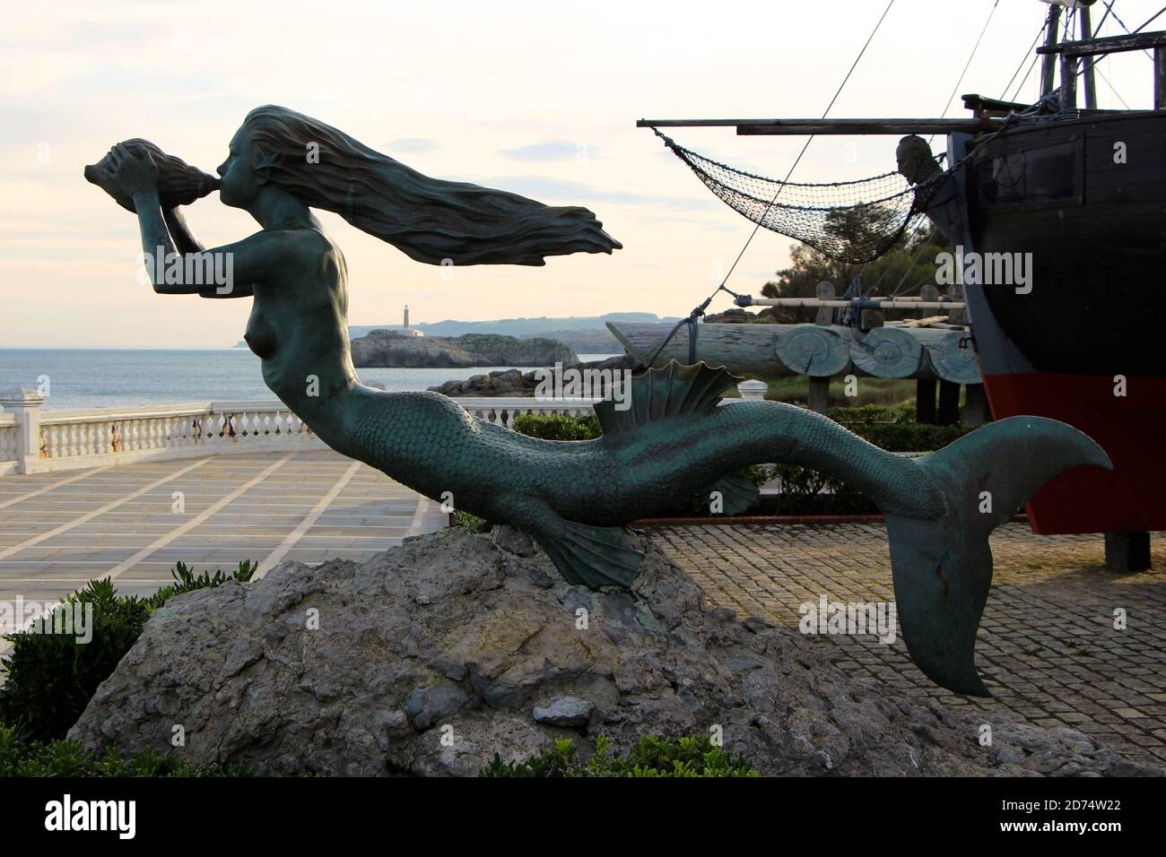 Bronze mermaid sculpture with long flowing hair blowing into a conch ...