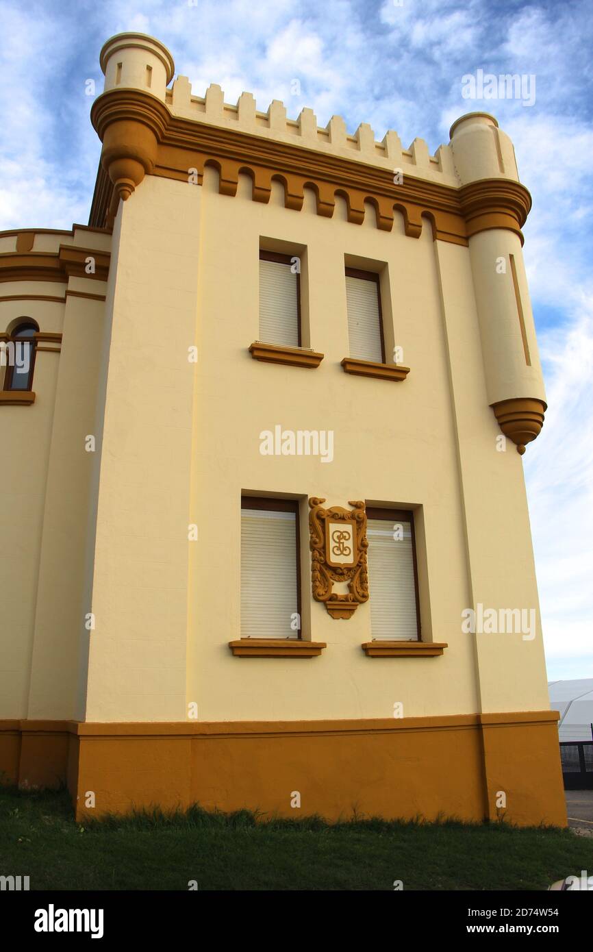 Brown and cream building with turrets and castellation at the entrance ...