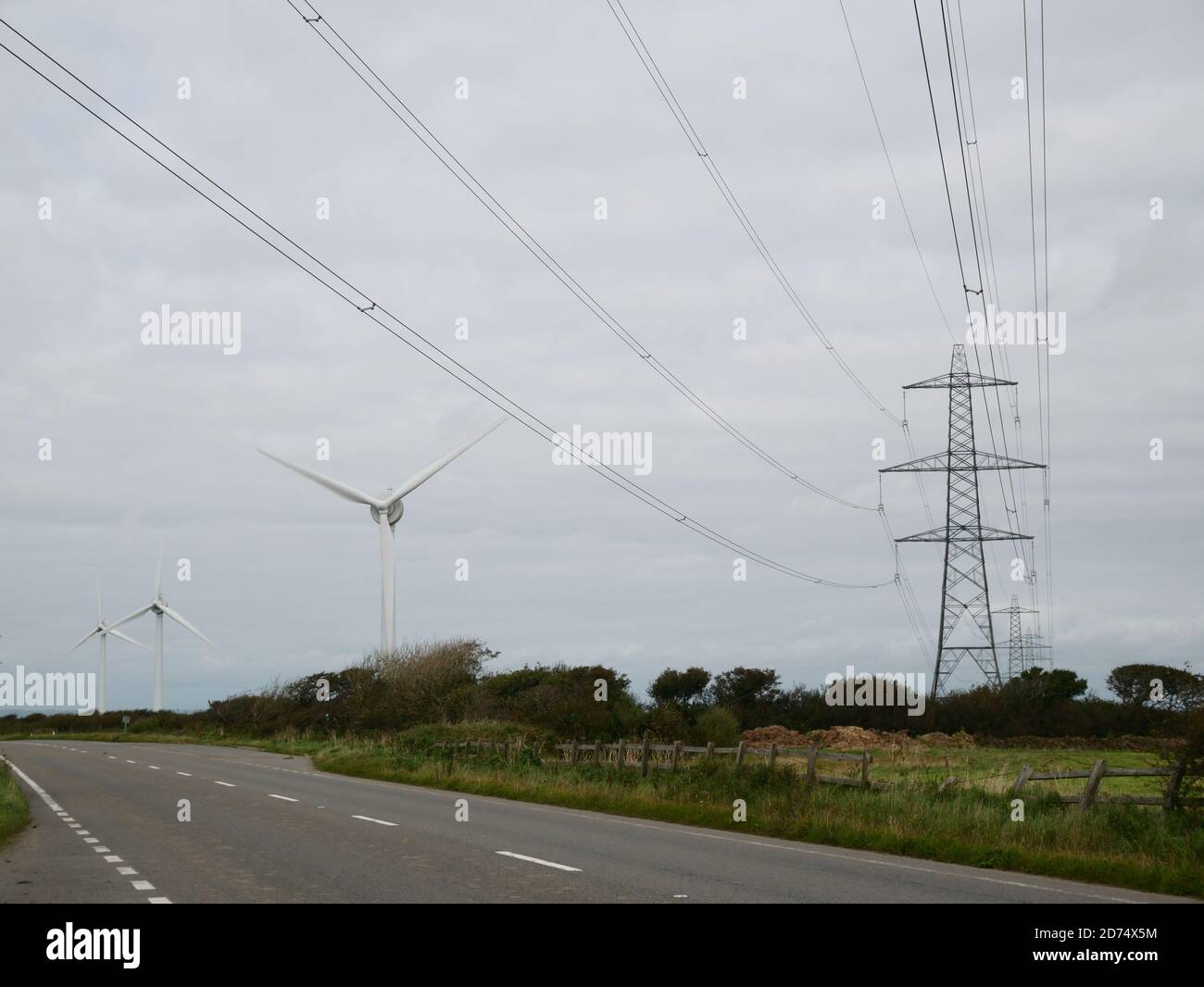 Wind turbines and electricity pylons along the A30 in Cornwall UK Stock ...