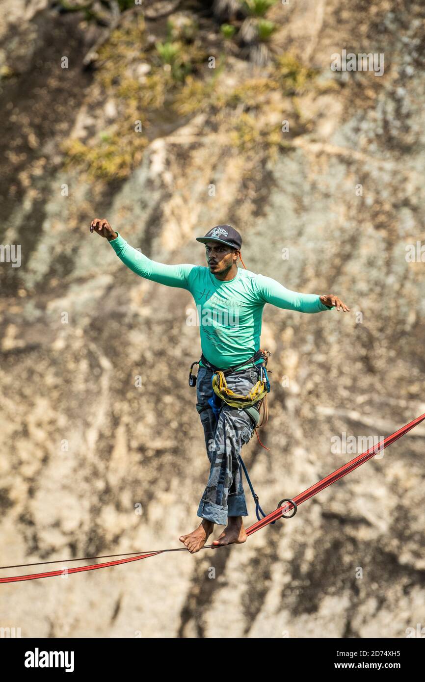 Beautiful view to highliner walking the line on rocky ocean front ...