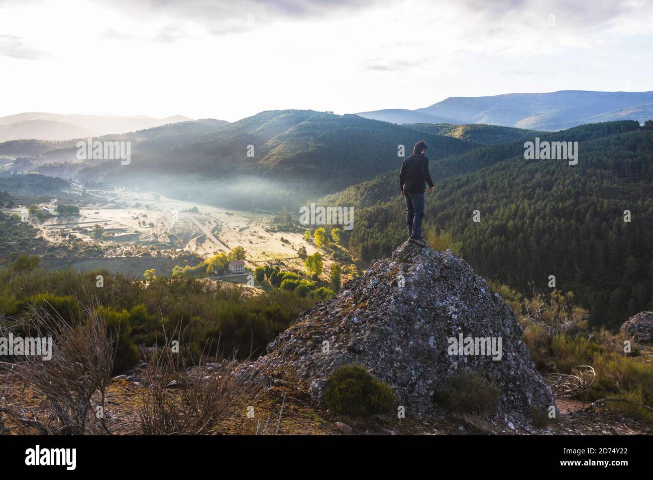 Man on the rock in the mountain watching the sunrise Stock Photo - Alamy