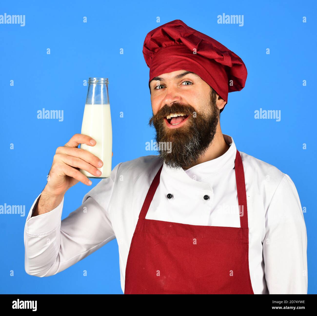 Nutritious lactose concept. Man with beard holds glass bottle on blue ...