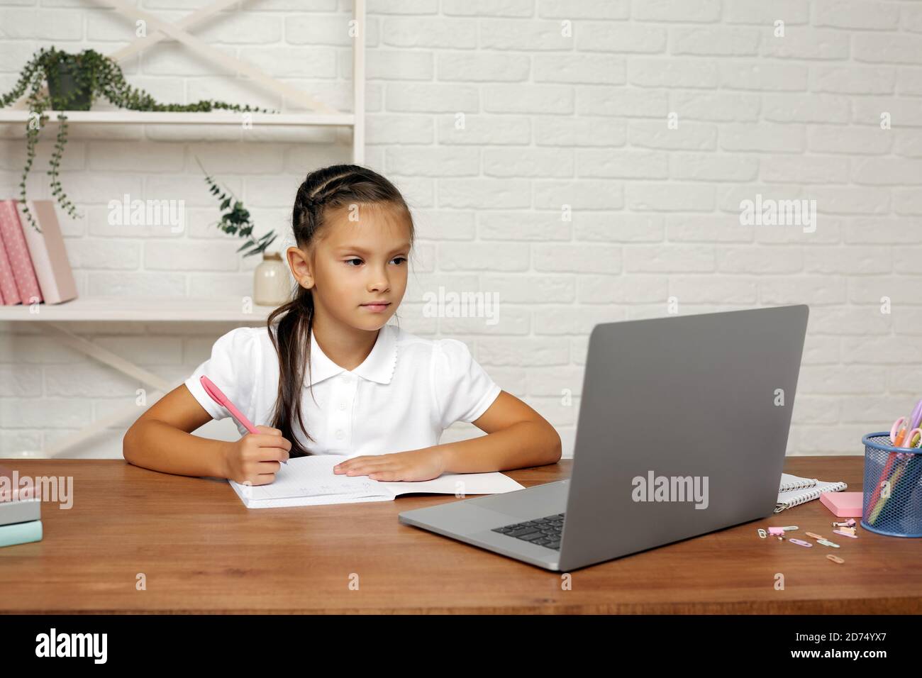 happy little child girl using laptop computer, studying through online ...