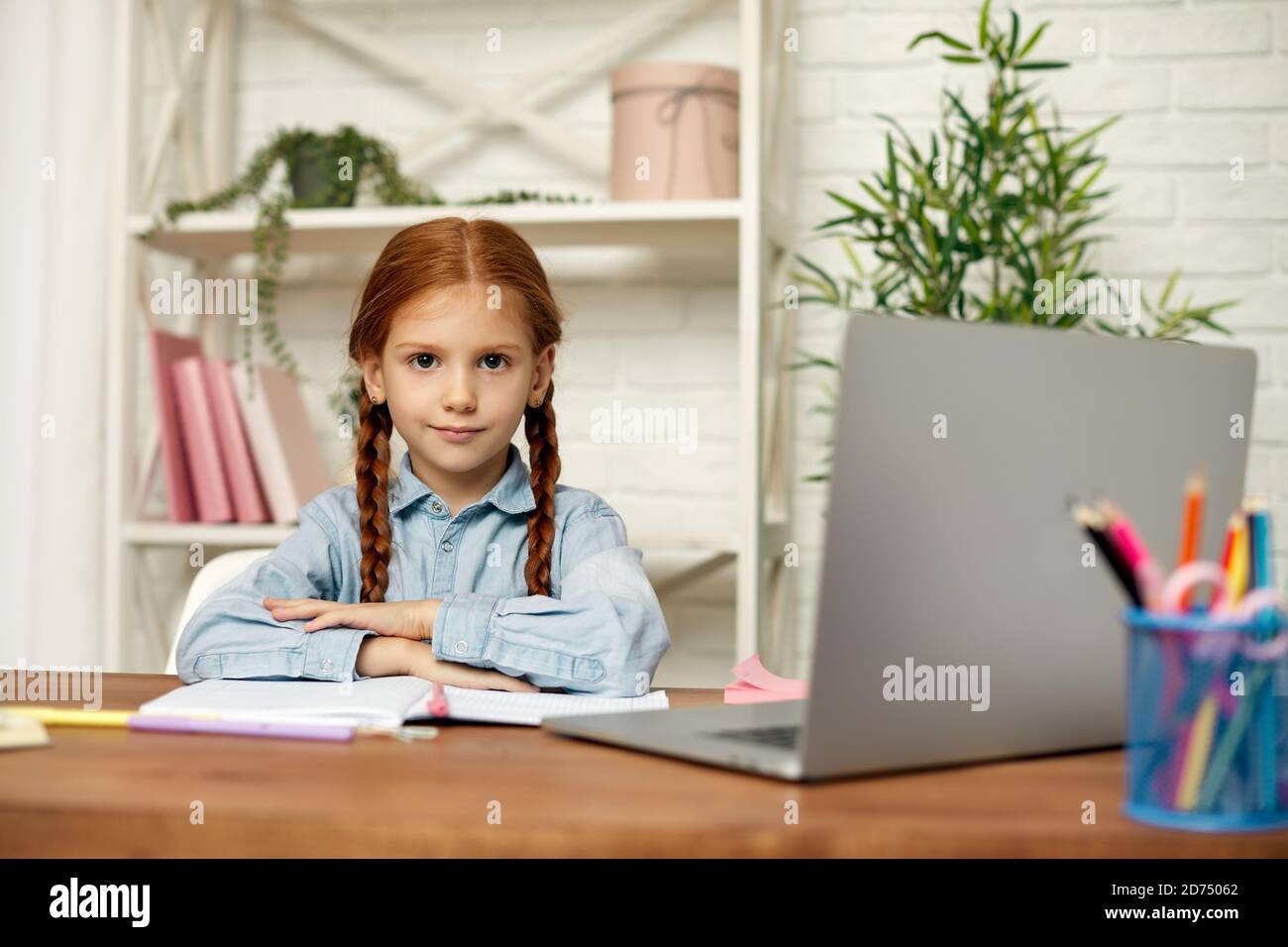 happy redhead little child girl using laptop for studying online ...