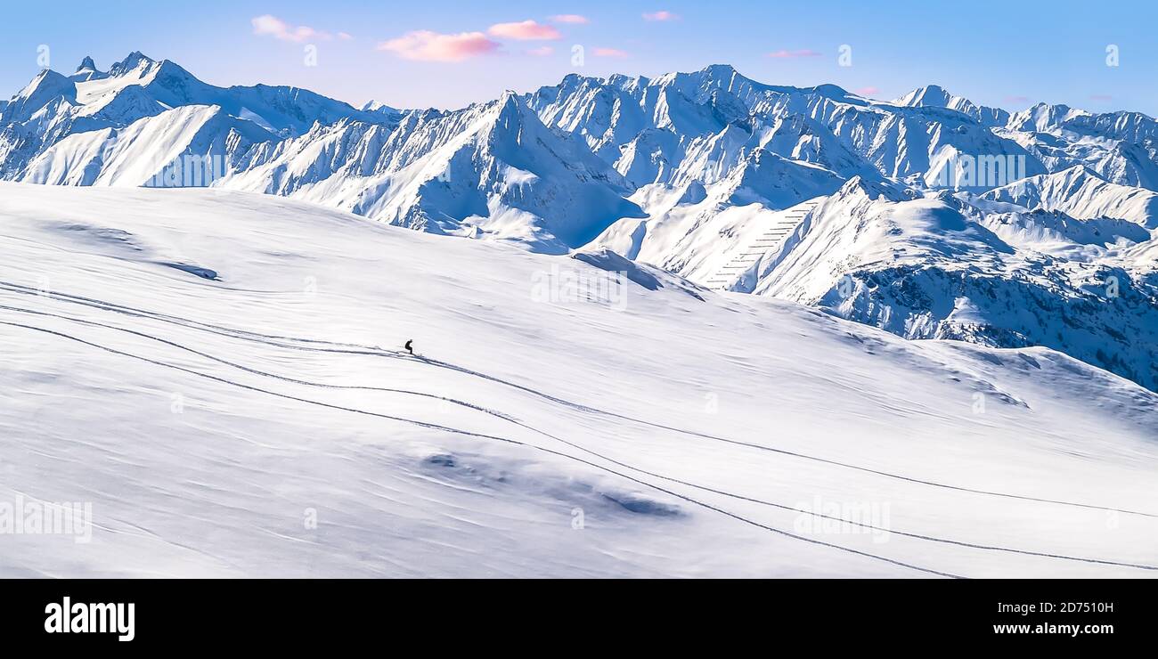 Single Skier going Downhill in Fresh Deep Snow in Front of Alpine ...