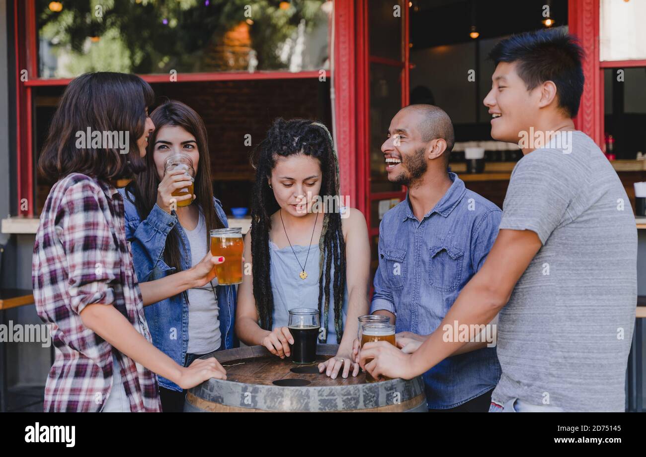 A group of international friends having fun and drinking beer in a ...